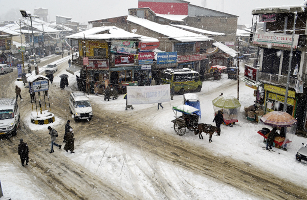 Life goes on amidst snowfall at Sopore on Tuesday. —Excelsior/Aabid ...