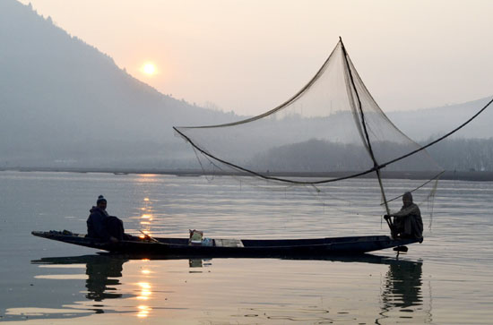 Fishermen cast their net in the Asia’s largest fresh water Wullar lake ...