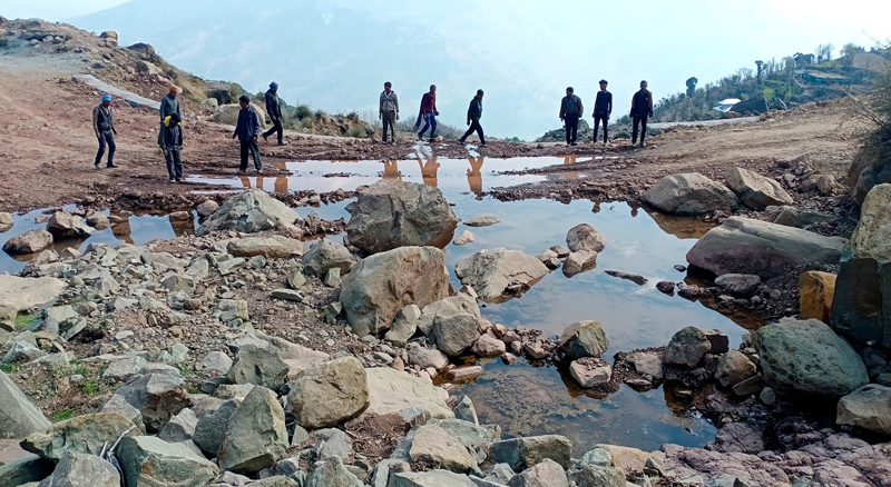 Locals crossing Deodi Nallah which has no bridge. - Daily Excelsior